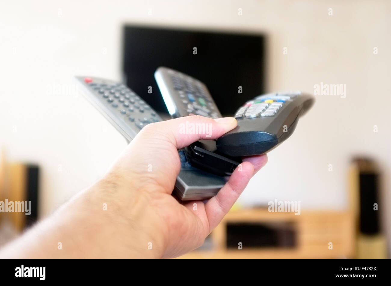 Three remote controls in one hand Stock Photo - Alamy