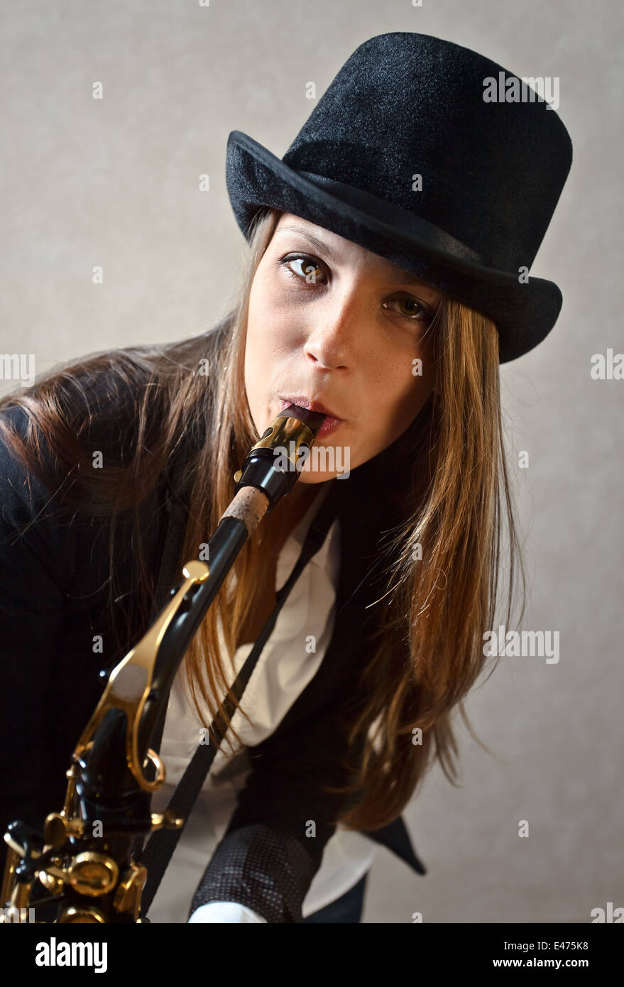 young beautiful woman in black hat with saxophone Stock Photo - Alamy