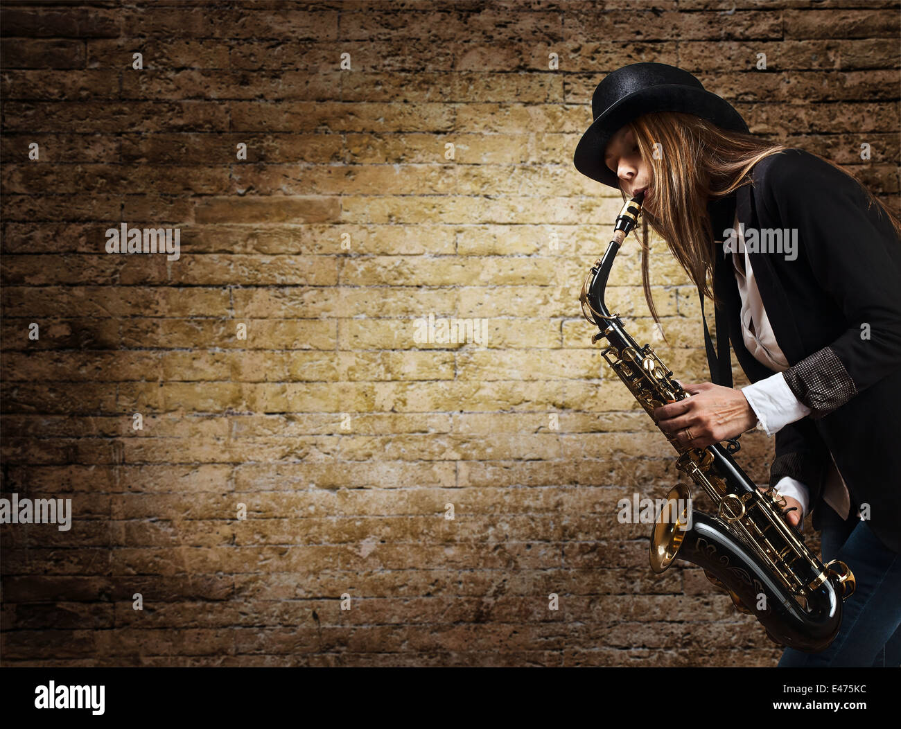 young beautiful woman in black hat with saxophone Stock Photo - Alamy
