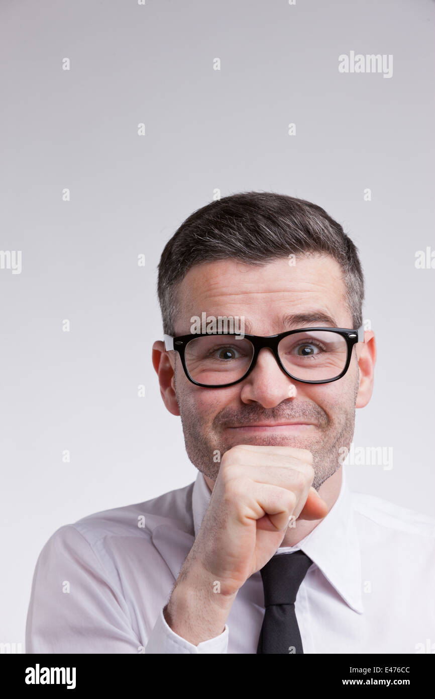 a nerdy man with a good idea in mind with glasses and smiling at camera ...
