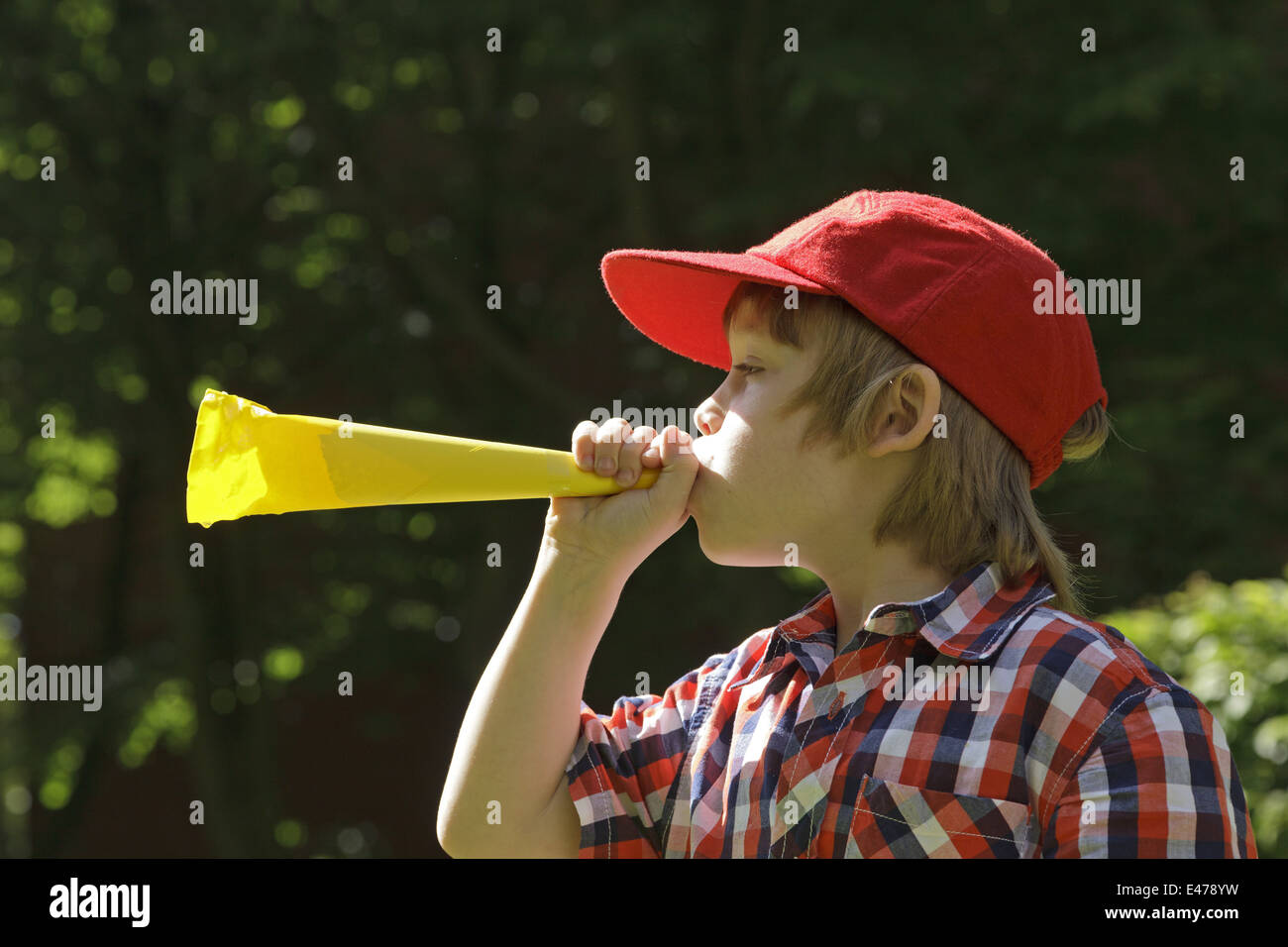 portrait of a young boy blowing a self-made noisemaker Stock Photo - Alamy