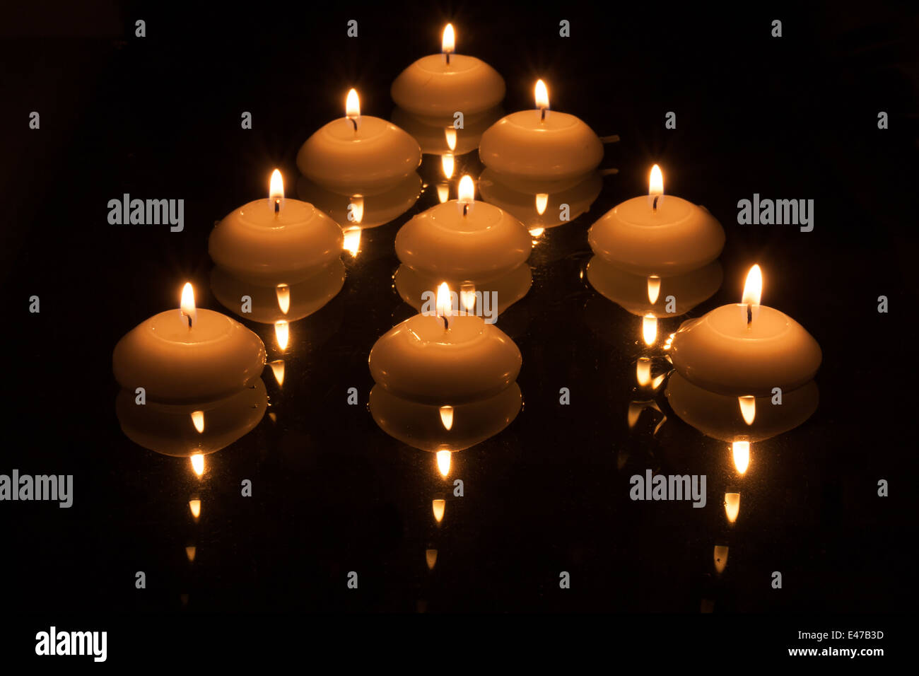 Nine reflection candles in the water Stock Photo - Alamy