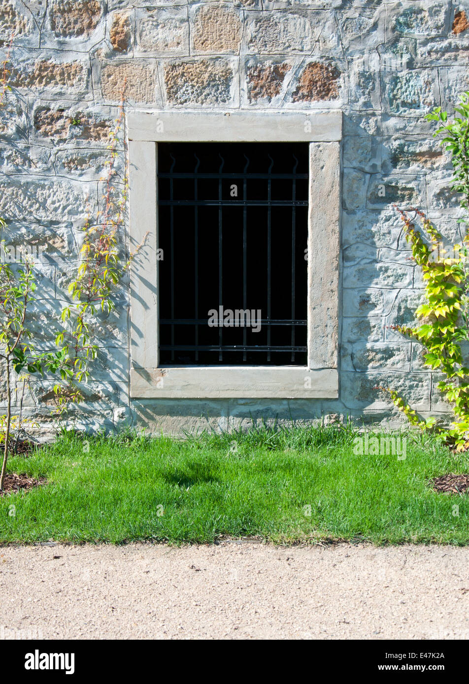Barred window in old stone wall on castle Stock Photo - Alamy