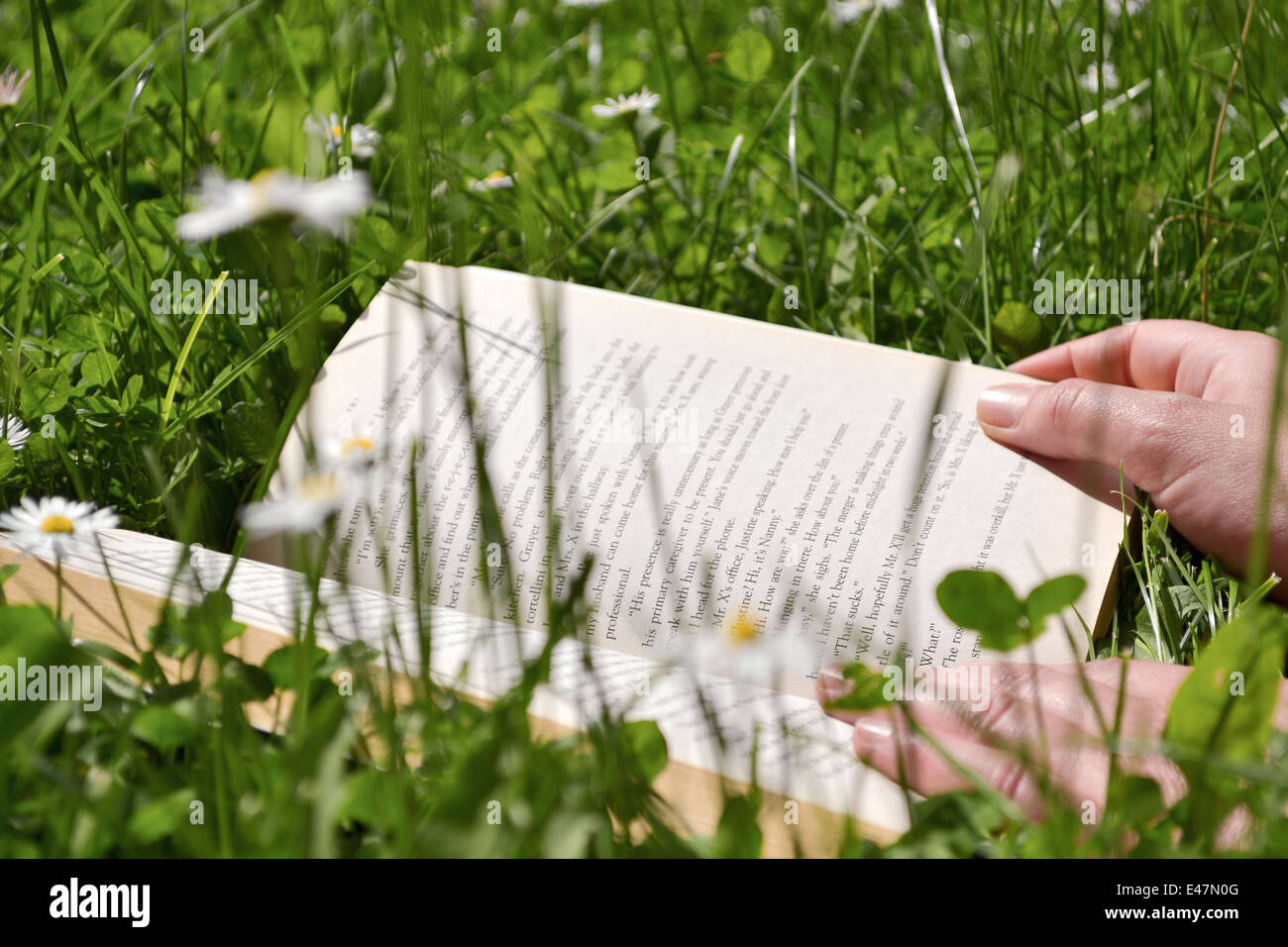 A woman lying and reading on a meadow in peace Stock Photo - Alamy