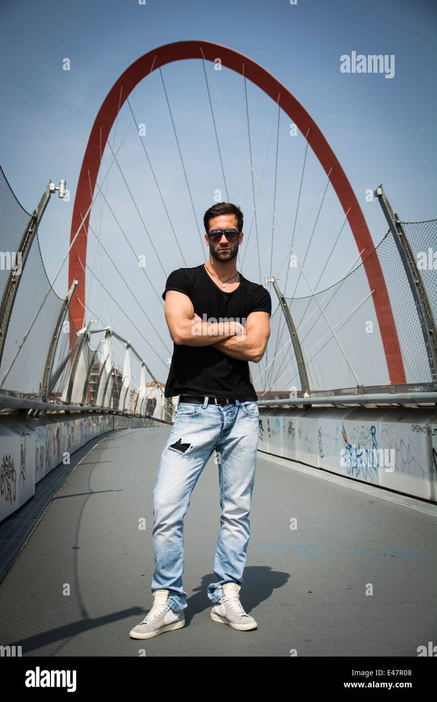 Handsome young man standing outdoors in front of Olympic Arch in Turin ...