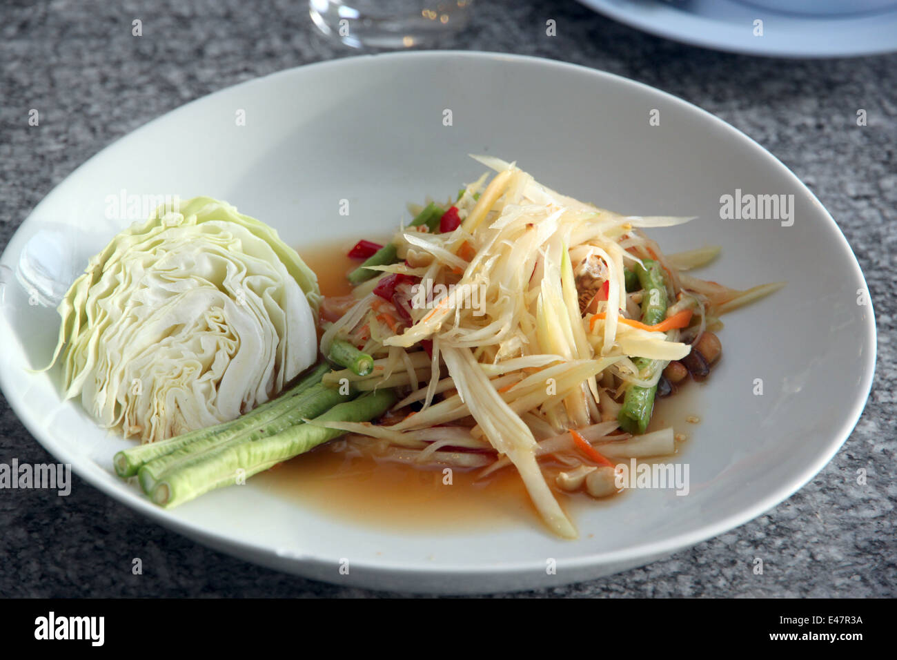 green papaya salad in white dish on the foods table Stock Photo - Alamy