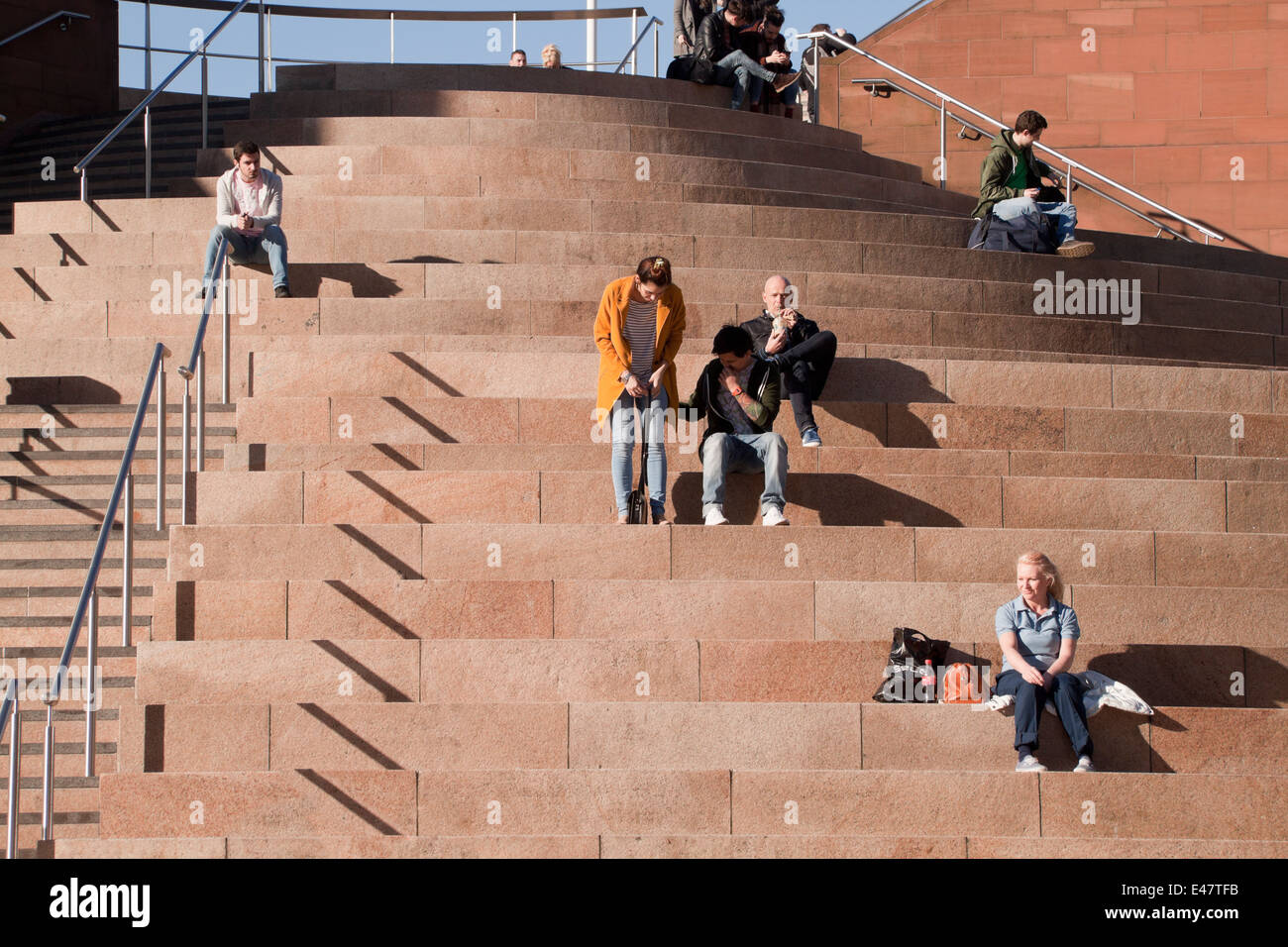 People relaxing in the sunshine on the steps near Liverpool One ...