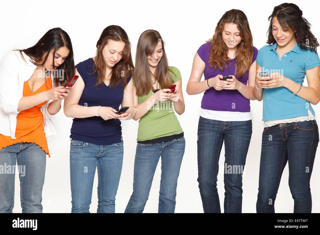a group of five girls having fun and hanging out while texting on the ...