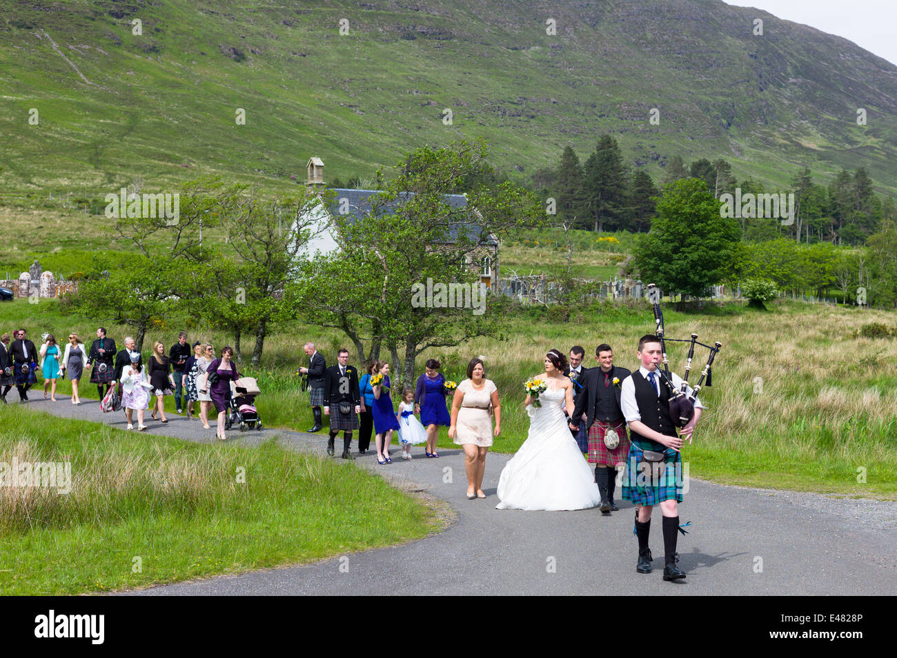 Highland Scottish wedding. Piper leads procession of bride, groom and ...