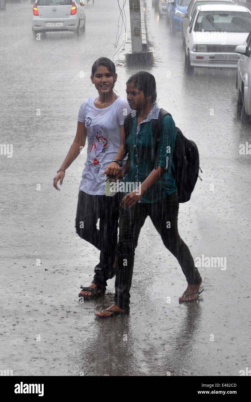 The young girls enjoy crossing the road during rain in Allahabad. It is ...
