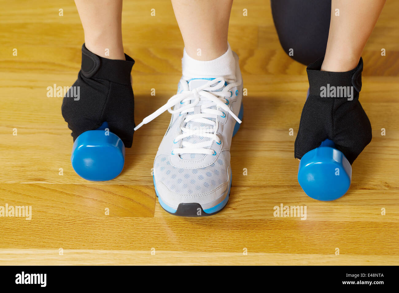 Horizontal image of female hands picking up small dumbbell weights ...