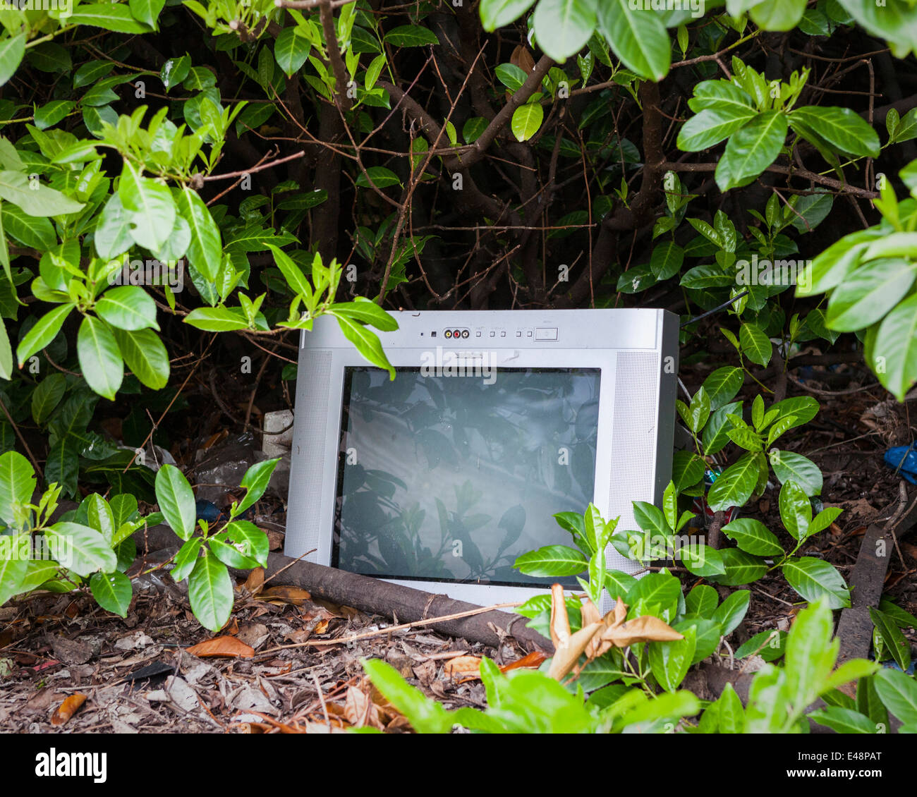 Old broken computer dumped in the bushes outside the closed and disused ...