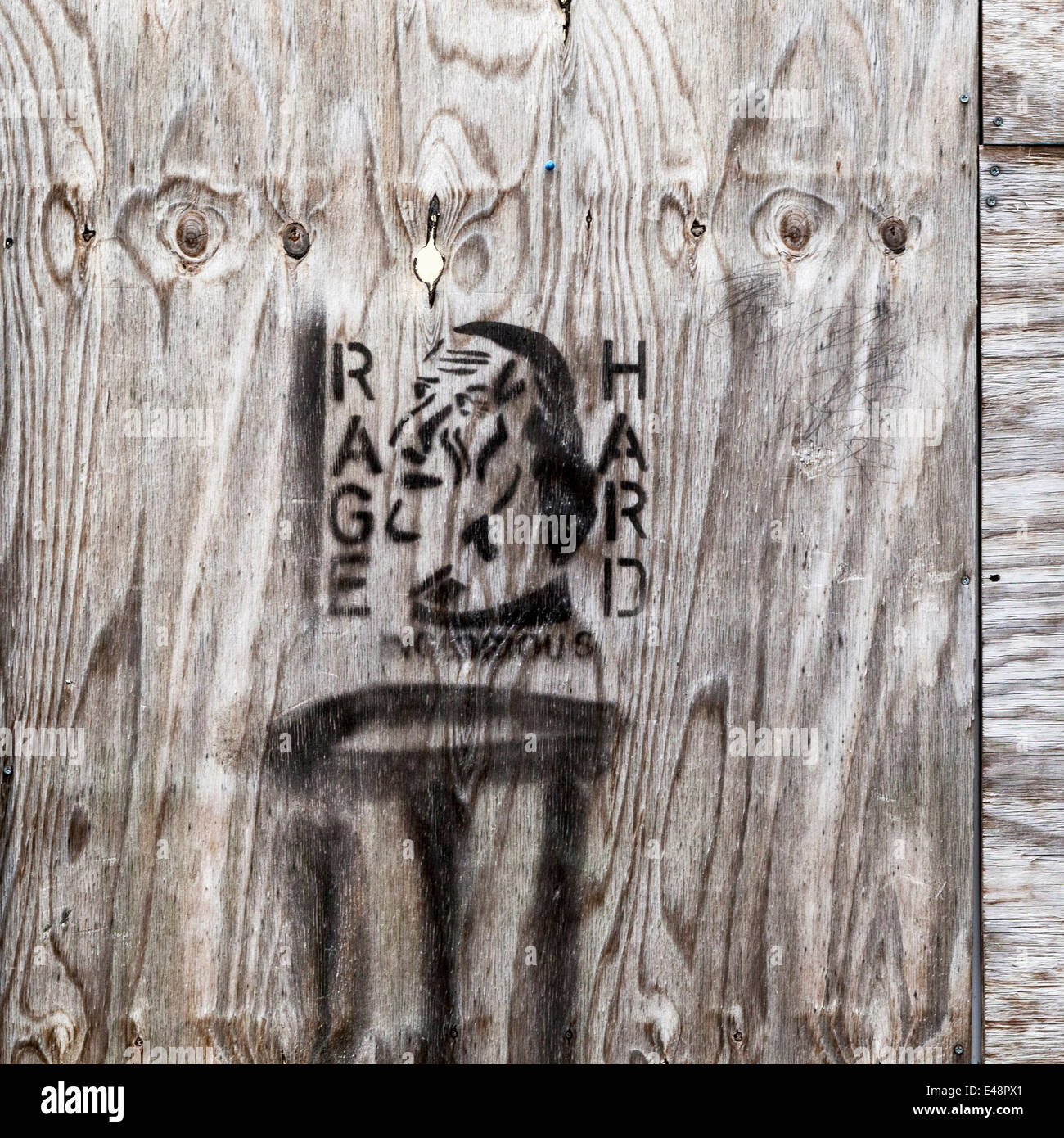 Street art stencil and graffiti. face with 'Rage Hard' text.on closed ...