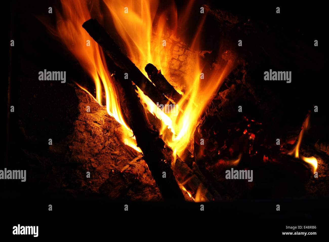 Open log fire burning and charring wood and producing embers Stock ...