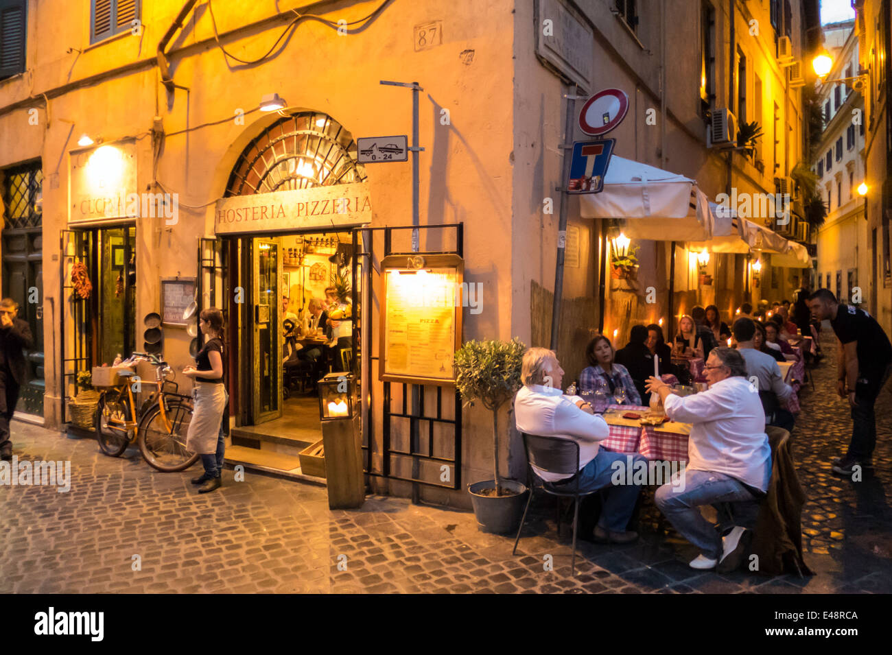 Outdoor restaurants in a cobbled street in Rome at night Stock Photo ...
