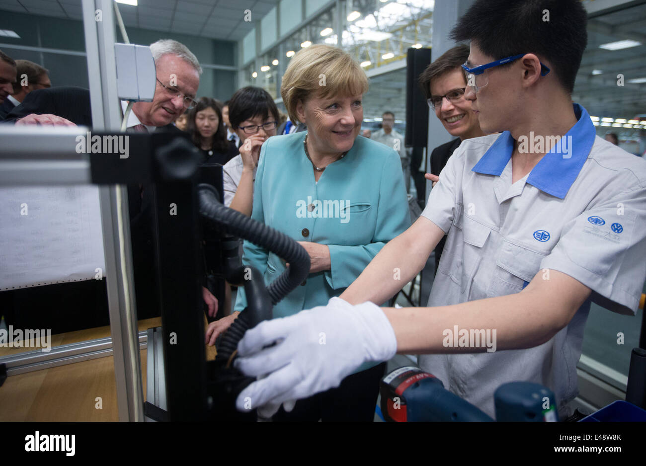 German Chancellor Angela Merkel (C) and Martin Winterkorn (L), chairman ...