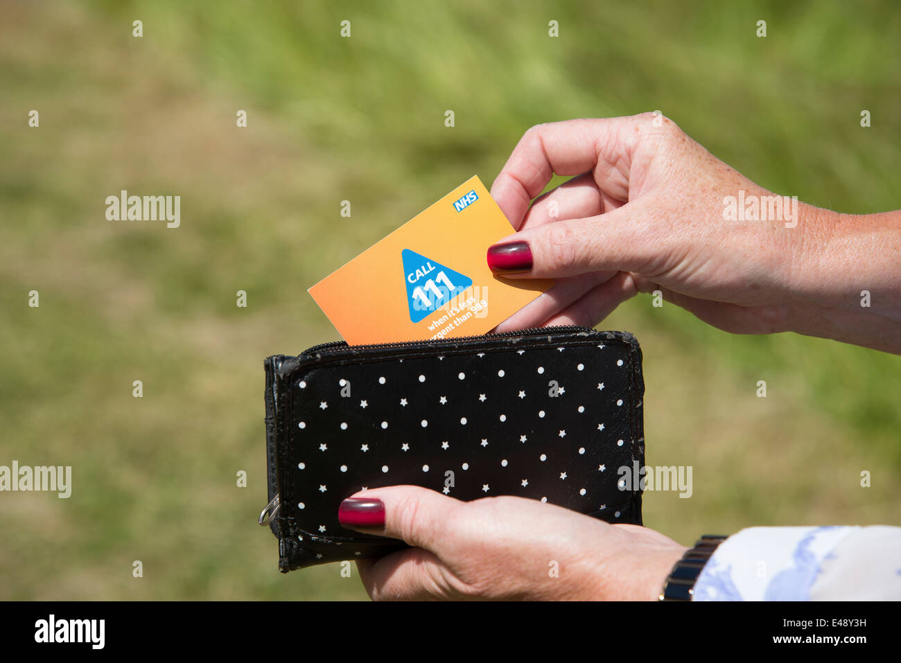NHS 111 card for use in an emergency Woman taking a card from her purse ...