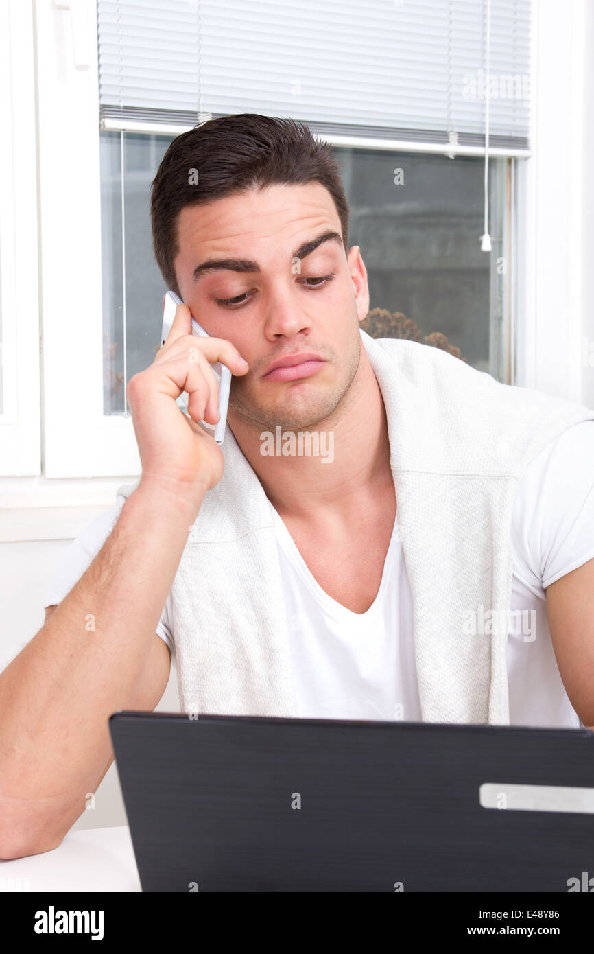 focused and surprised casual handsome man talking on mobile phone in ...