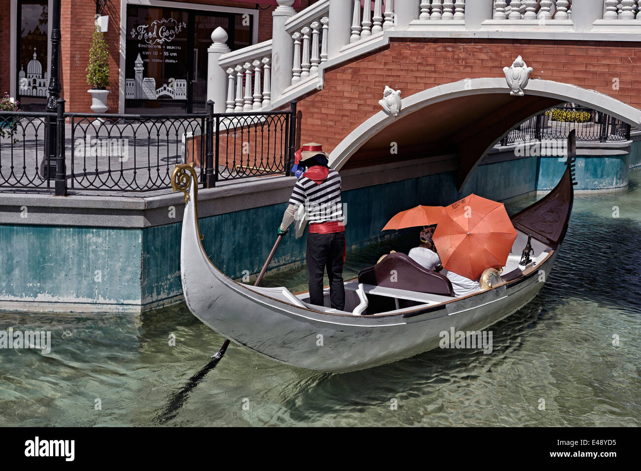 Gondolier and gondola navigating canal way. The Venezia Hua Hin ...