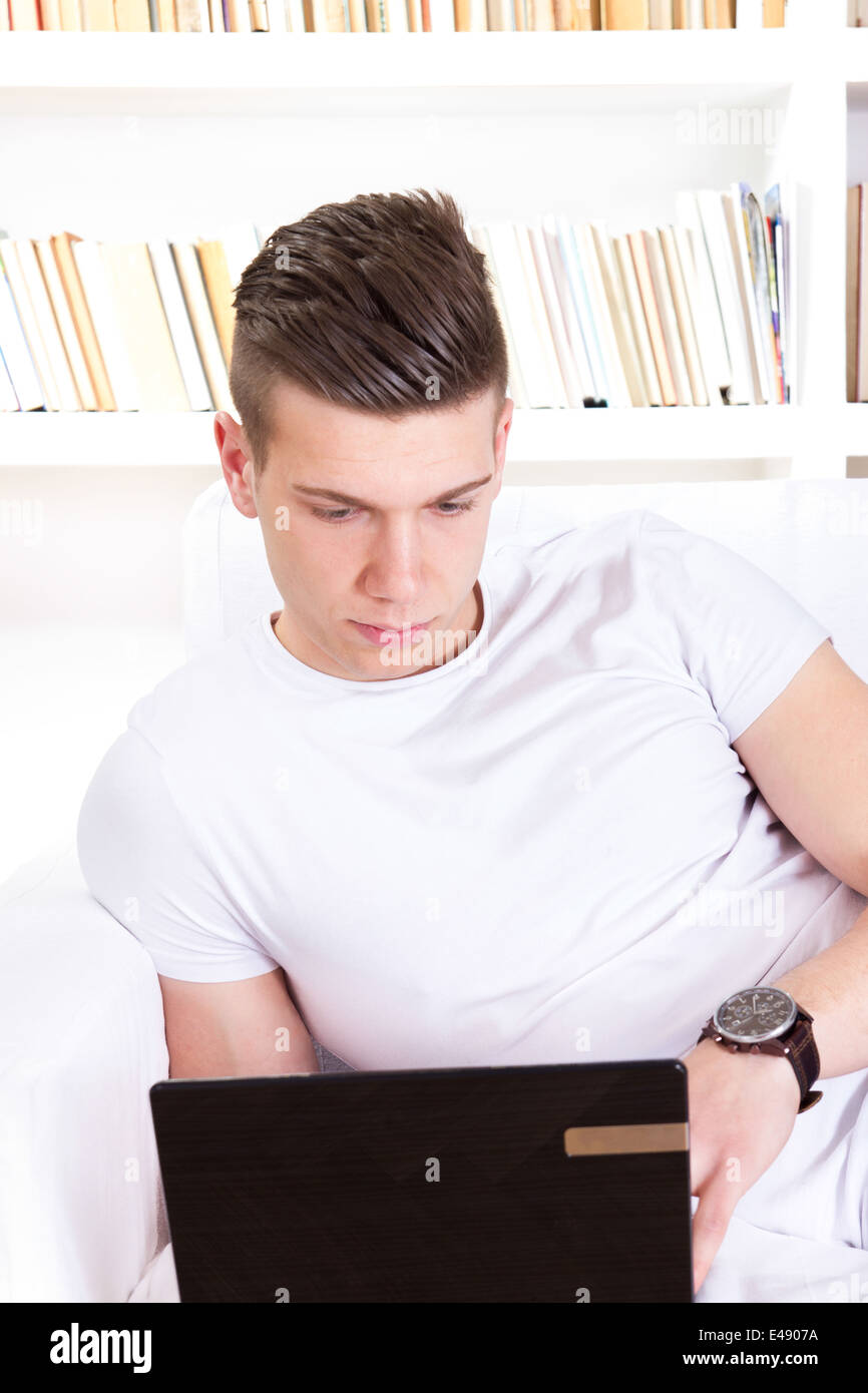 thoughtful young man chatting on laptop computer at home Stock Photo ... thoughtful young man chatting on laptop computer at home Stock Photo ...