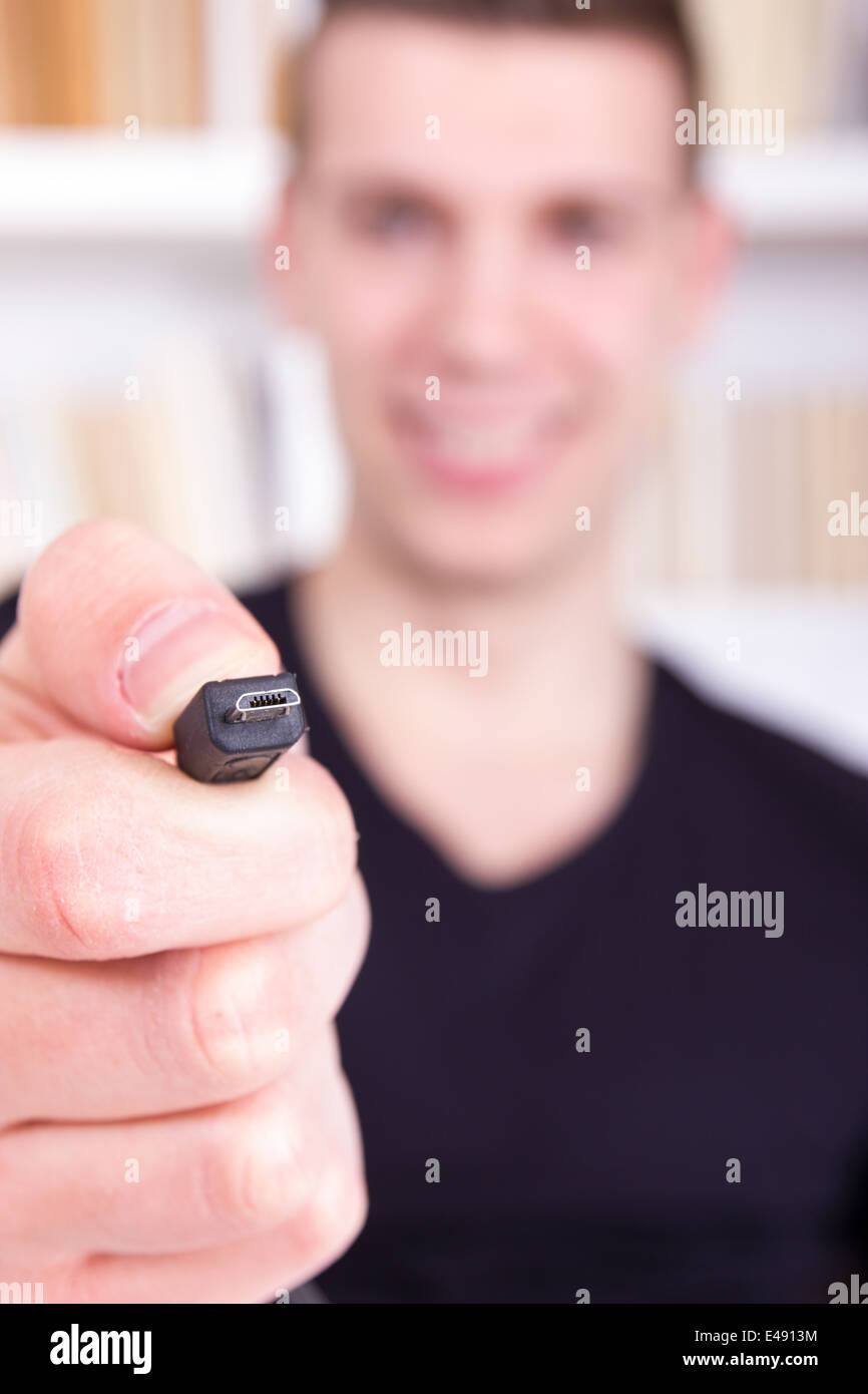 man holding and showing black micro USB cable, micro usb port connector ...