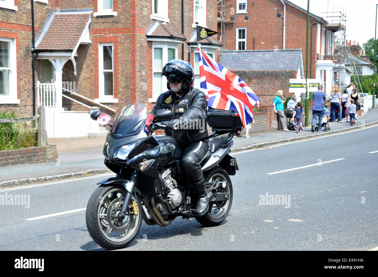 A motorcyclist carries a Union Jack flag in the summer parade and fair ...