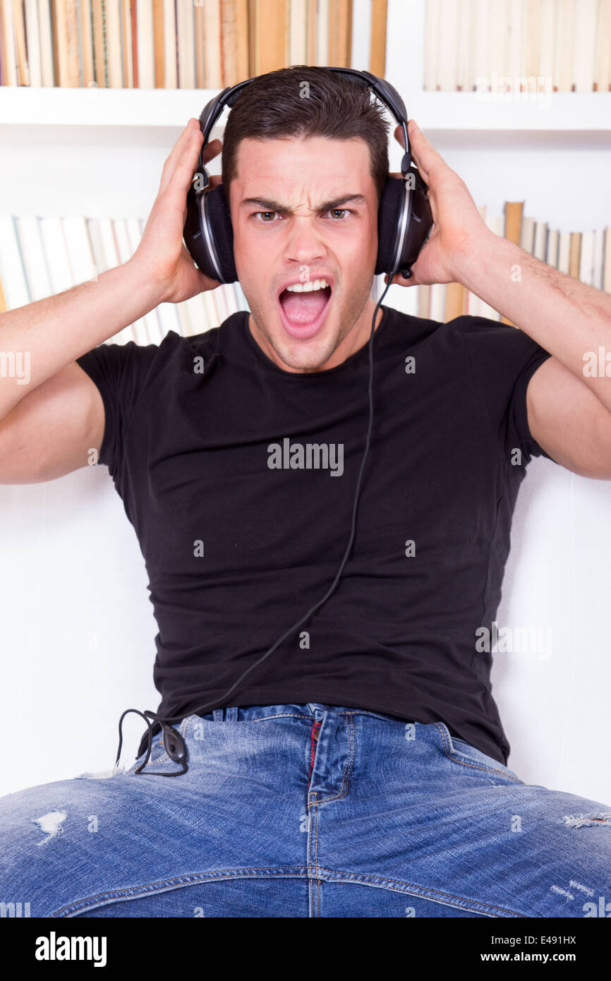 surprised and shocked casual man listening music on headphones in ...