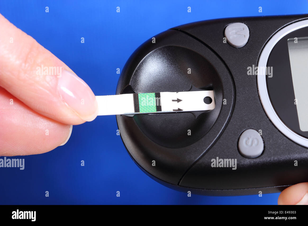 Closeup of strip for glucose testing and glucose meter, measuring sugar ...