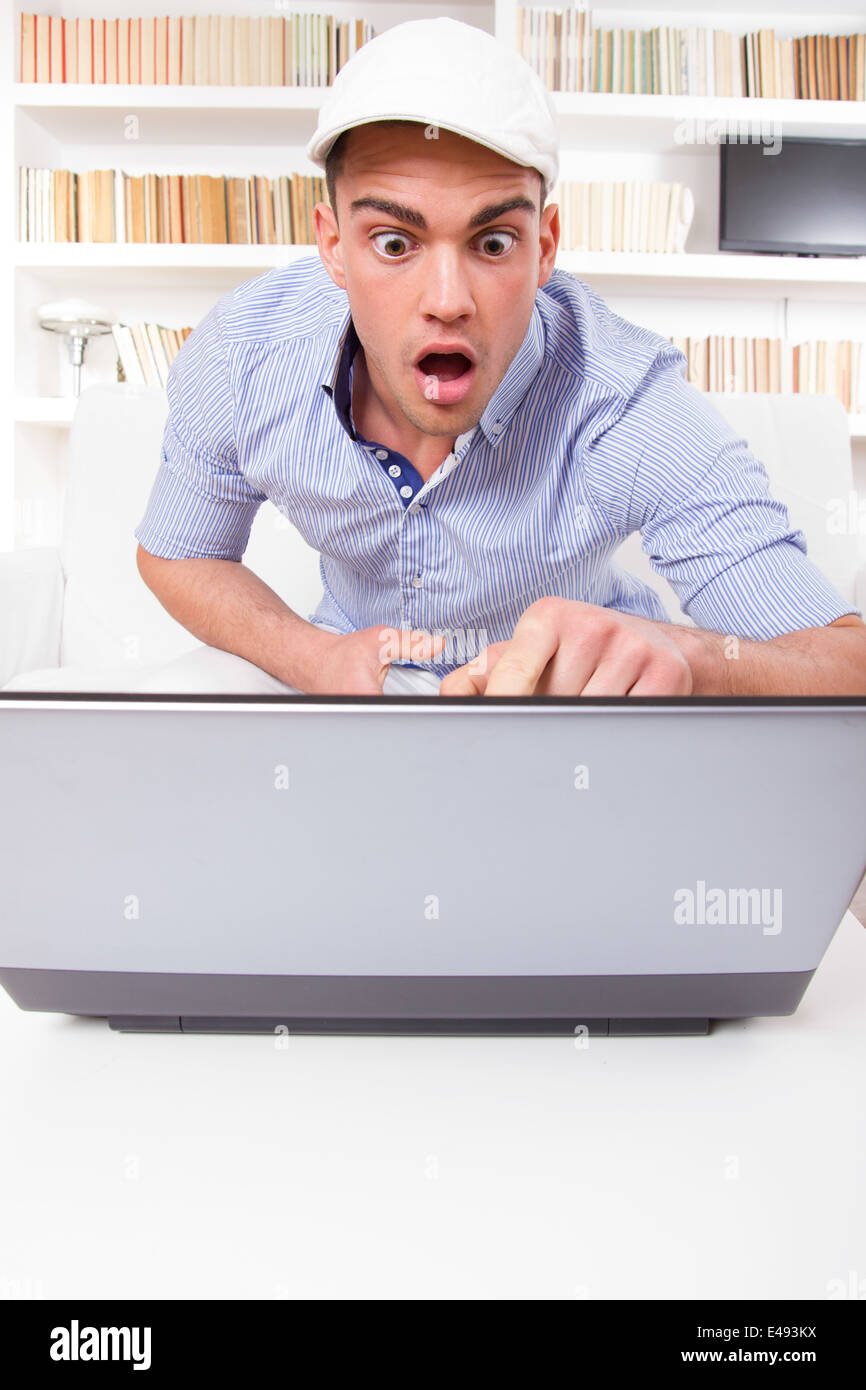 surprised man pointing at computer monitor with shock, wearing shirt ...