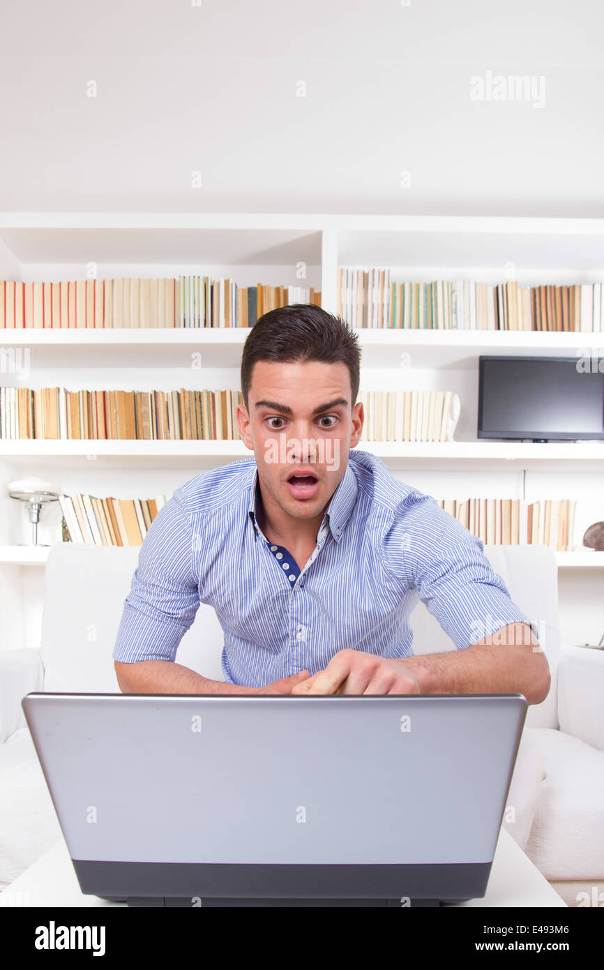 surprised college student looking at laptop monitor pointing shocked ...