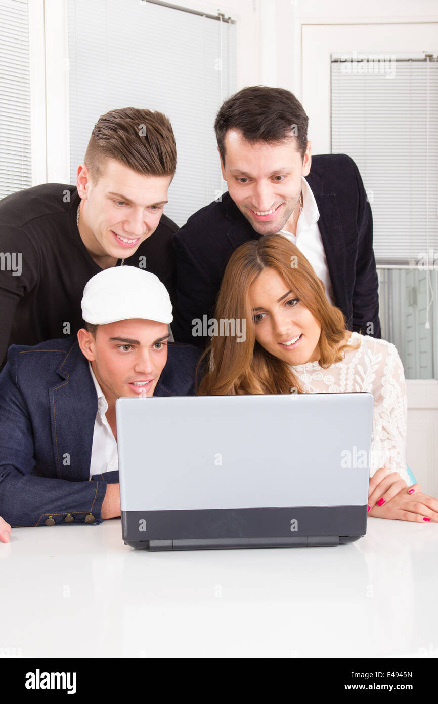 curious friends looking at laptop computer monitor together smiling ...