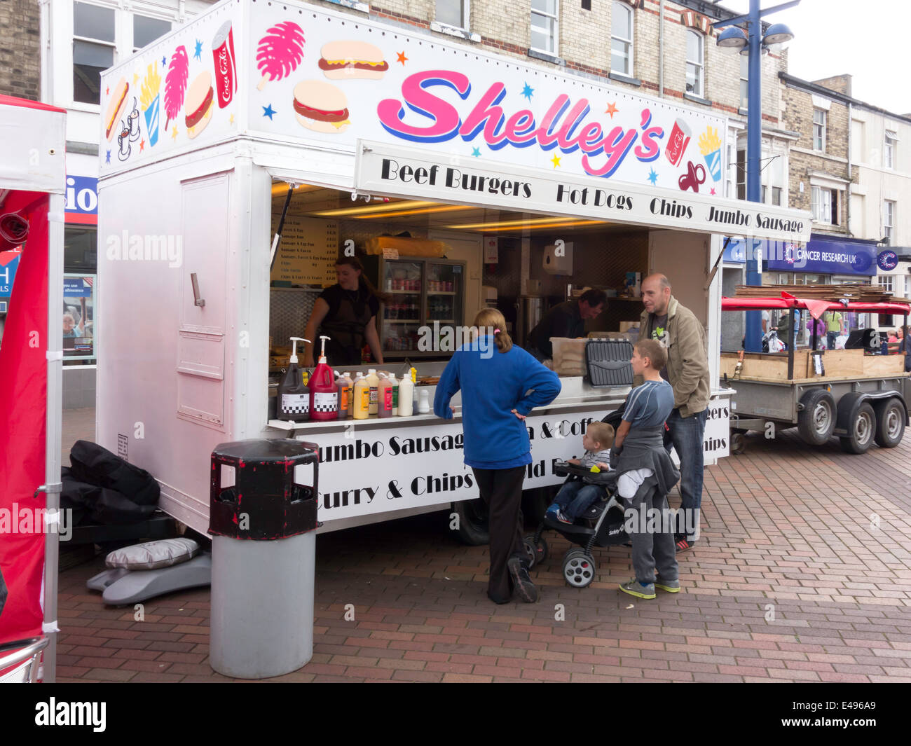 Family buying from Shelley's Diner fast food stall in the weekly Market ...