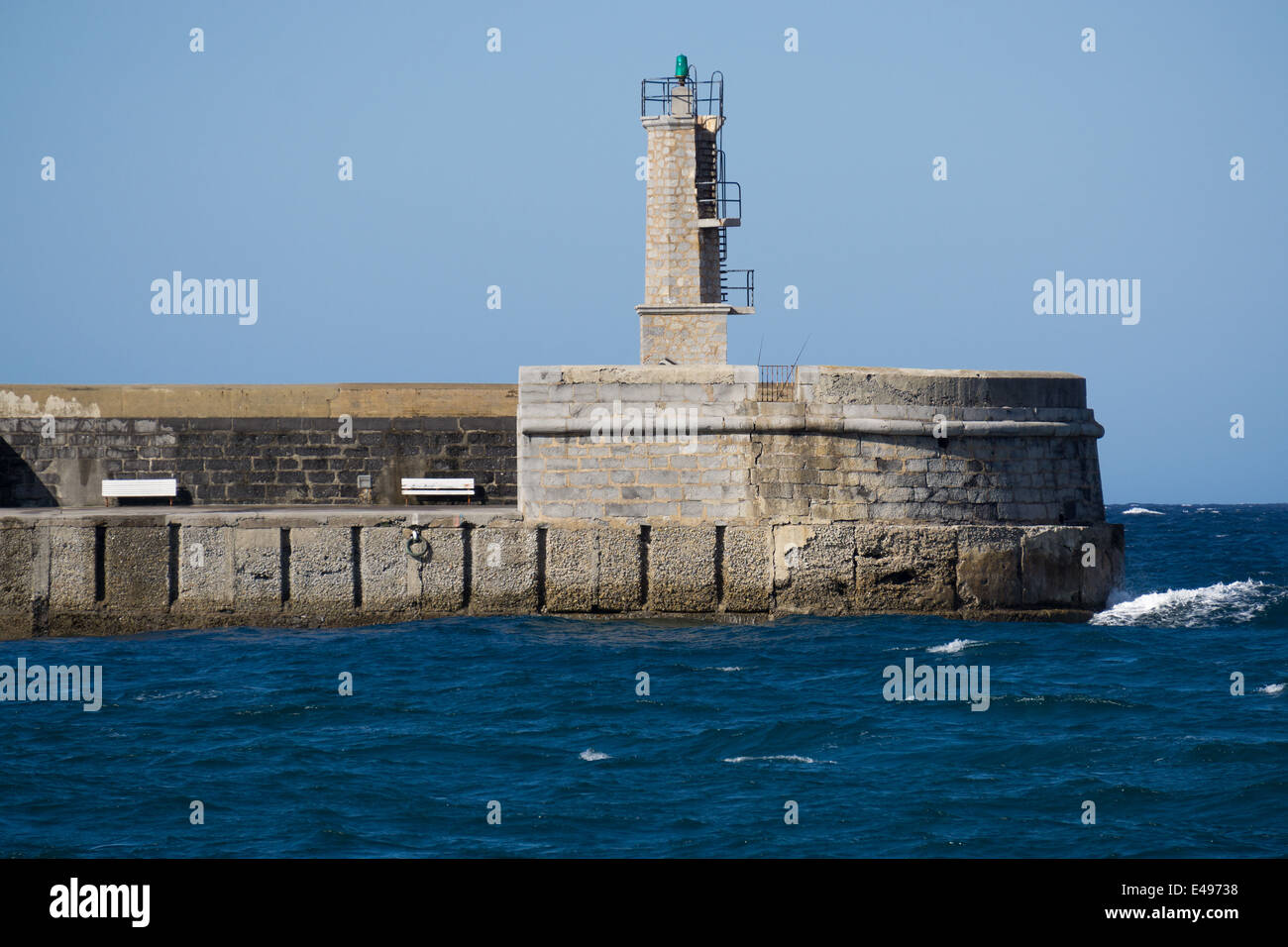 Stone Lighthouse over ocean and blue sky Stock Photo - Alamy
