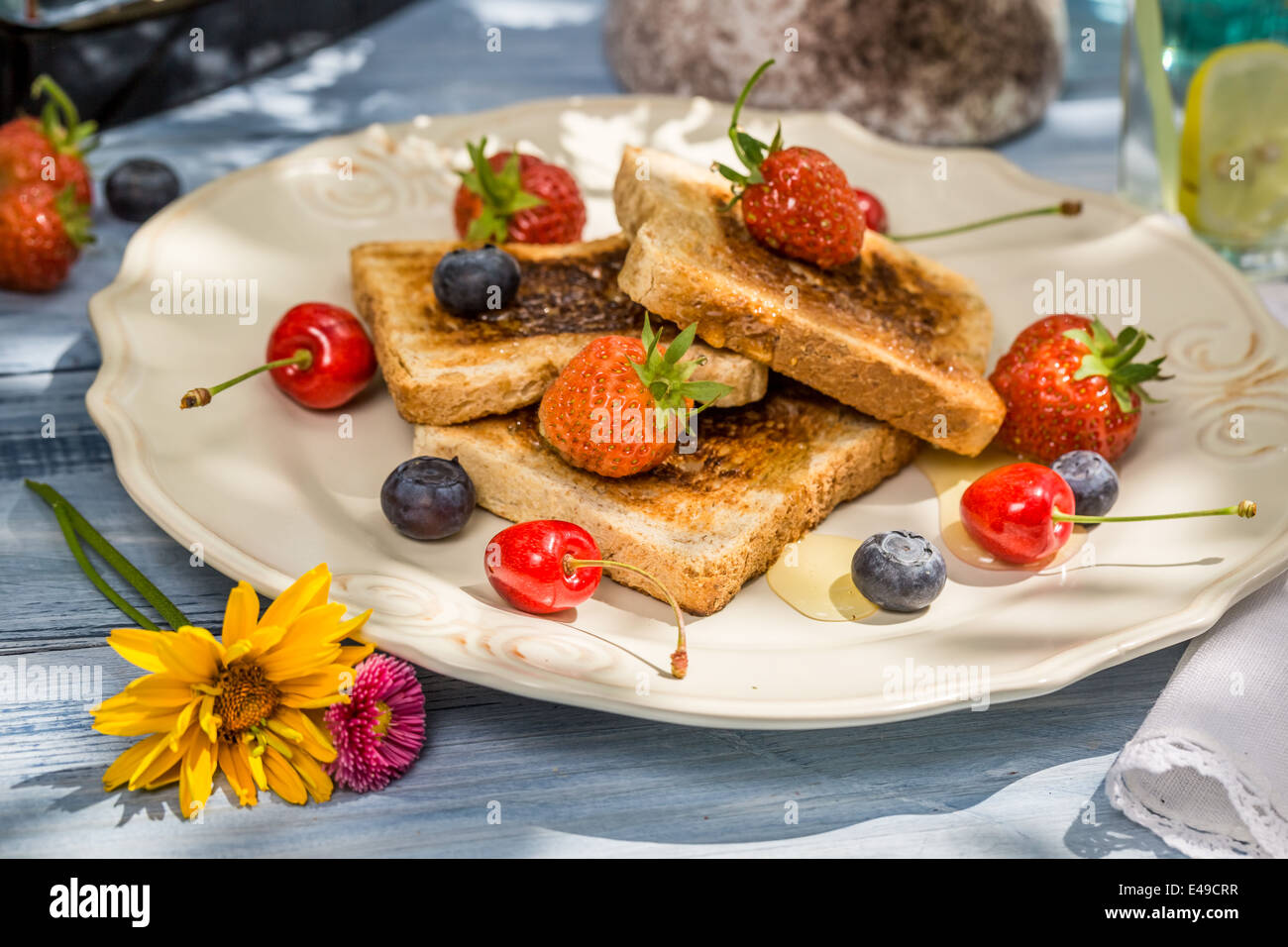 Toast with fruit and honey served in the garden Stock Photo - Alamy