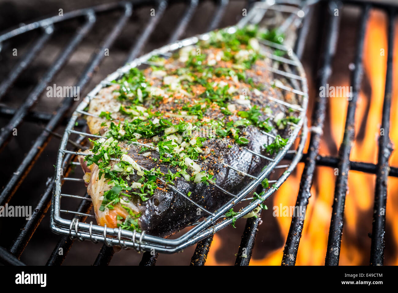 Grilled fish with spices on fire Stock Photo - Alamy
