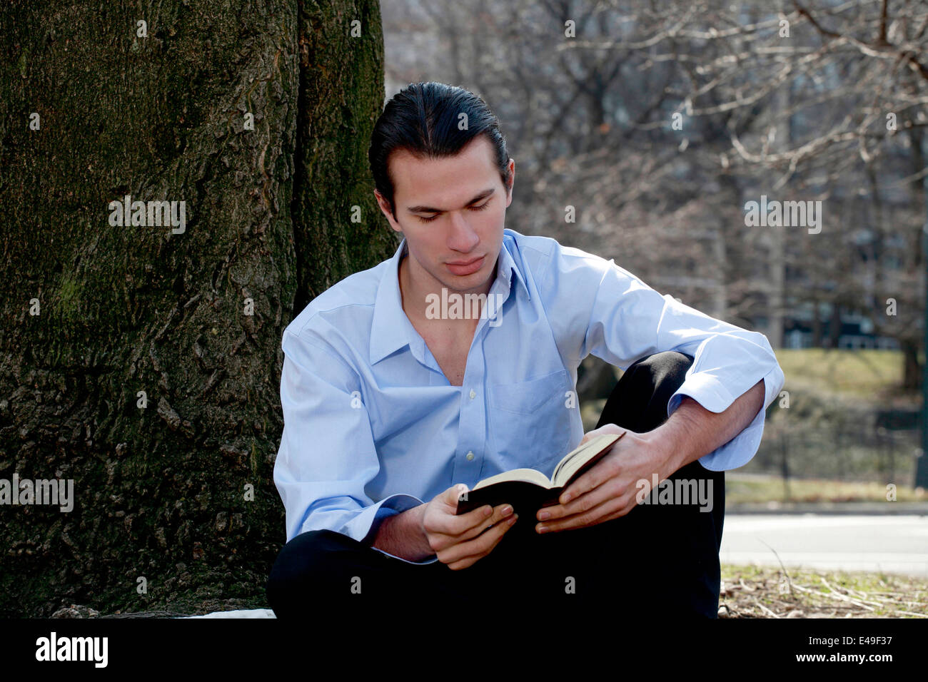 Man sitting outdoors and reading his Holy Bible Stock Photo - Alamy