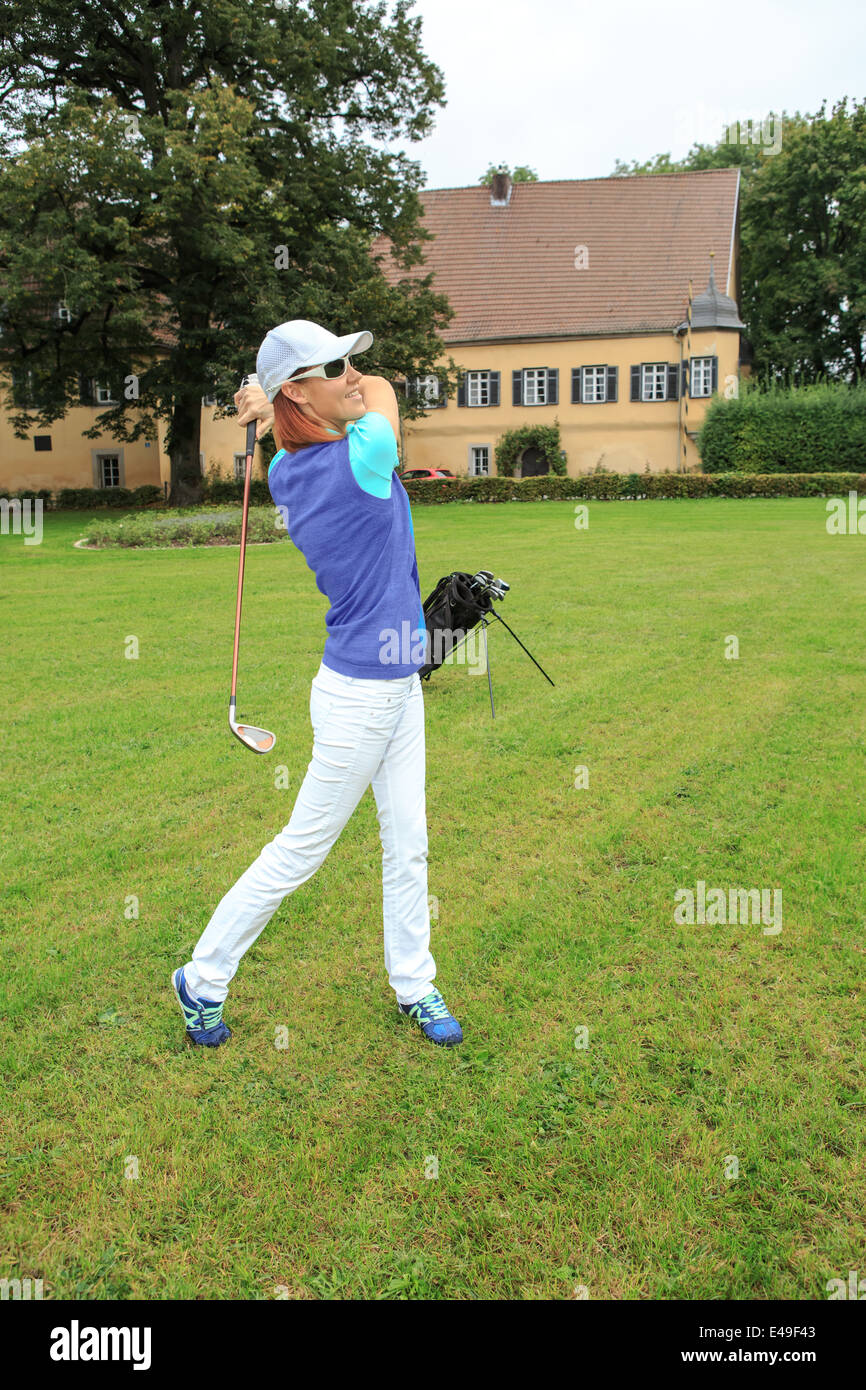 female golf player with a golf club on the course Stock Photo - Alamy
