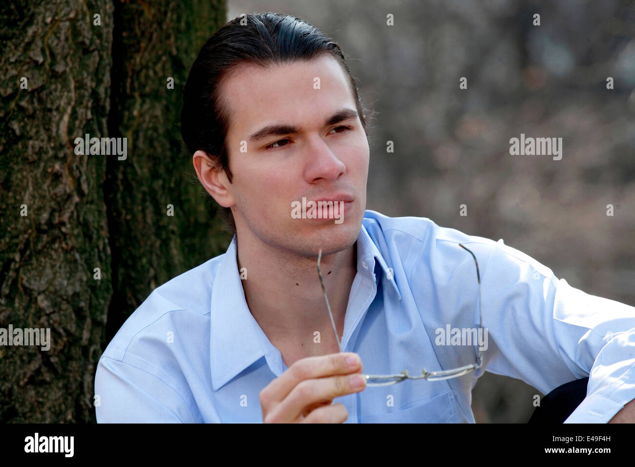 Male sitting outdoors in deep thought Stock Photo - Alamy