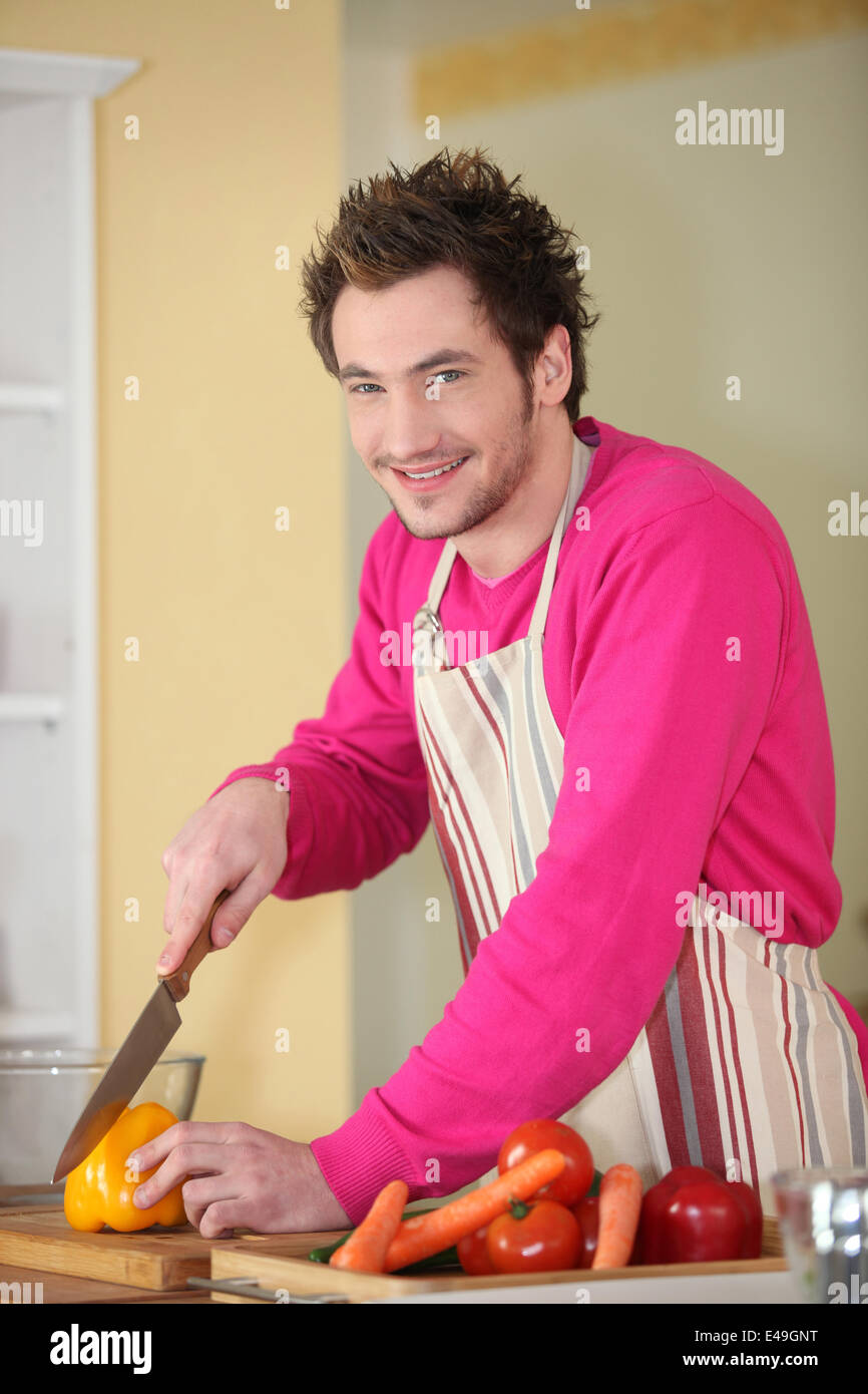 Young man chopping a bell pepper Stock Photo - Alamy