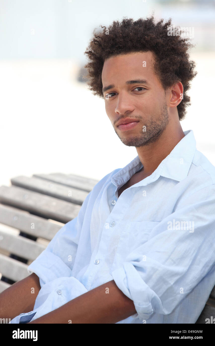 a young metis man sitting on wooden bench Stock Photo - Alamy