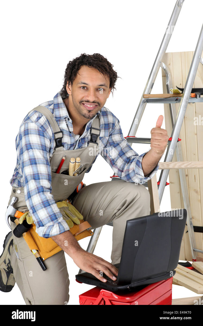 Happy laborer using computer Stock Photo - Alamy