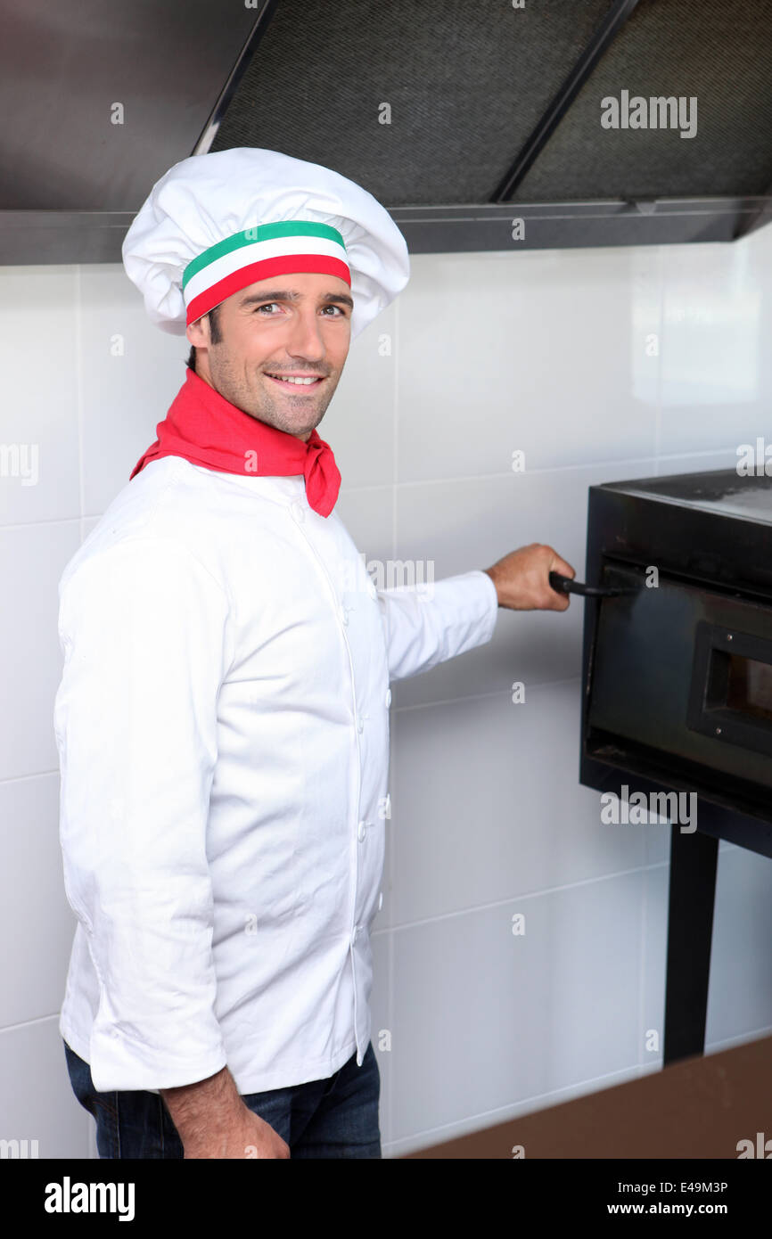 Italian chef next to a pizza oven Stock Photo - Alamy