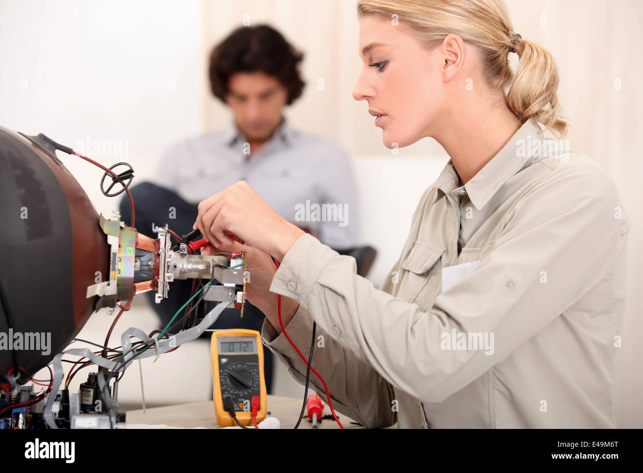 Woman fixing a television Stock Photo - Alamy