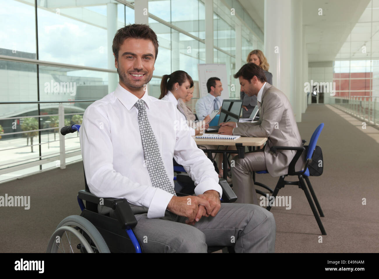 Disabled office worker with colleagues Stock Photo - Alamy