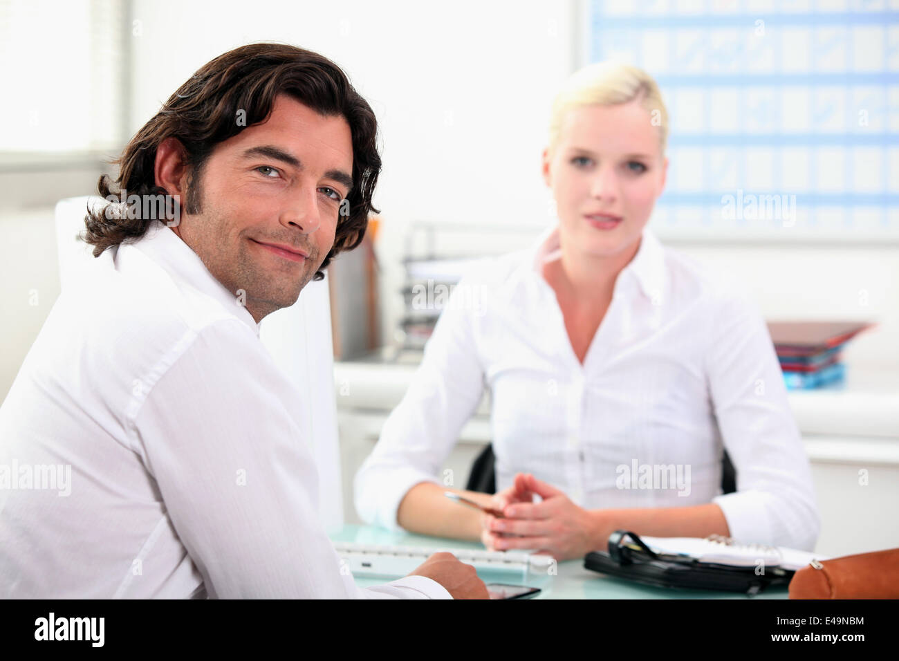 Colleagues chatting at a desk Stock Photo - Alamy