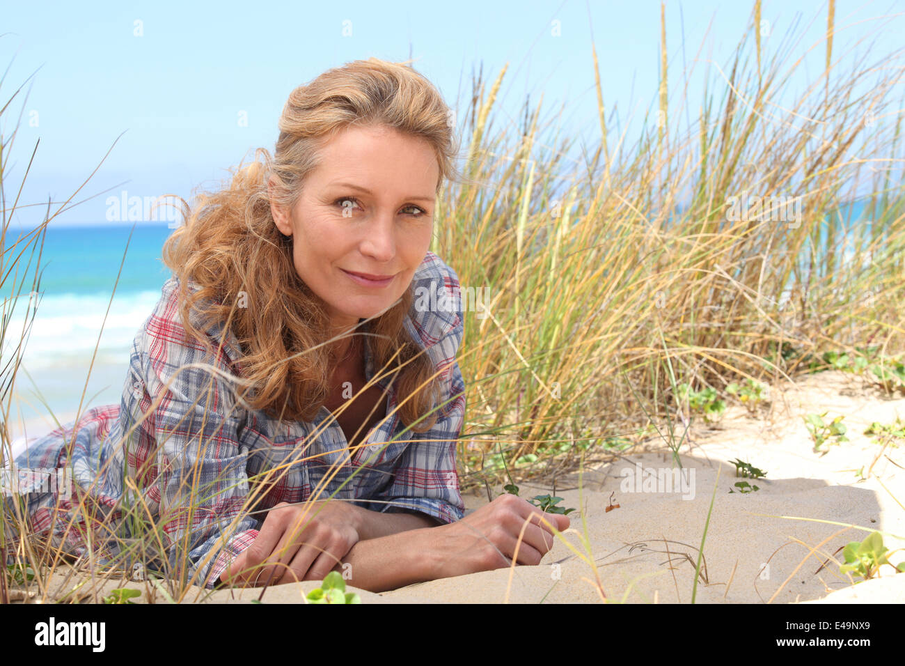 Woman laying on the sand Stock Photo - Alamy
