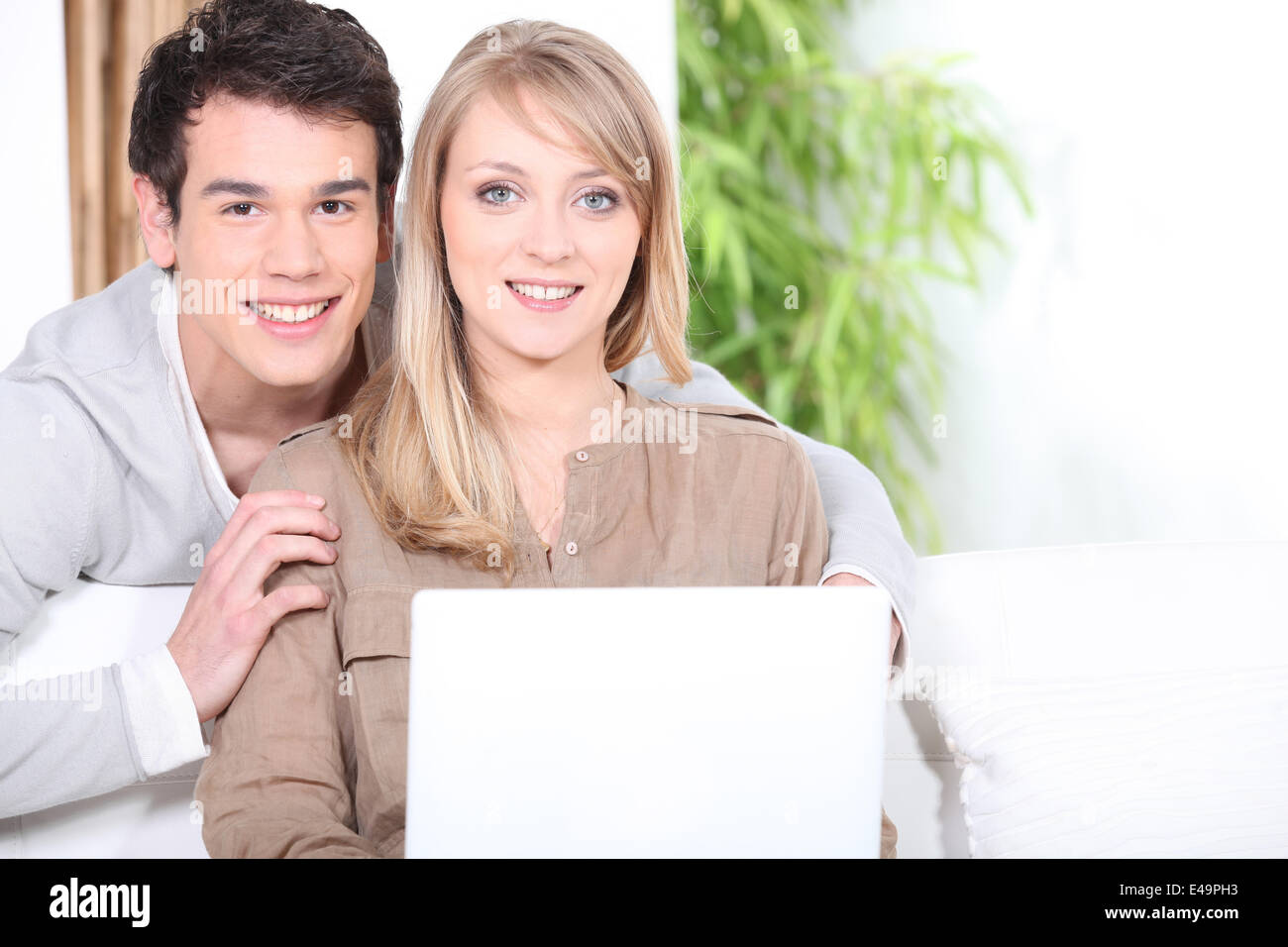 Young couple using a laptop computer indoors Stock Photo - Alamy