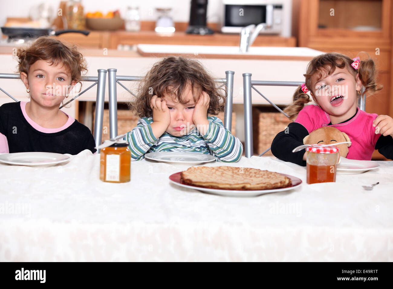 three children eating crepes Stock Photo - Alamy