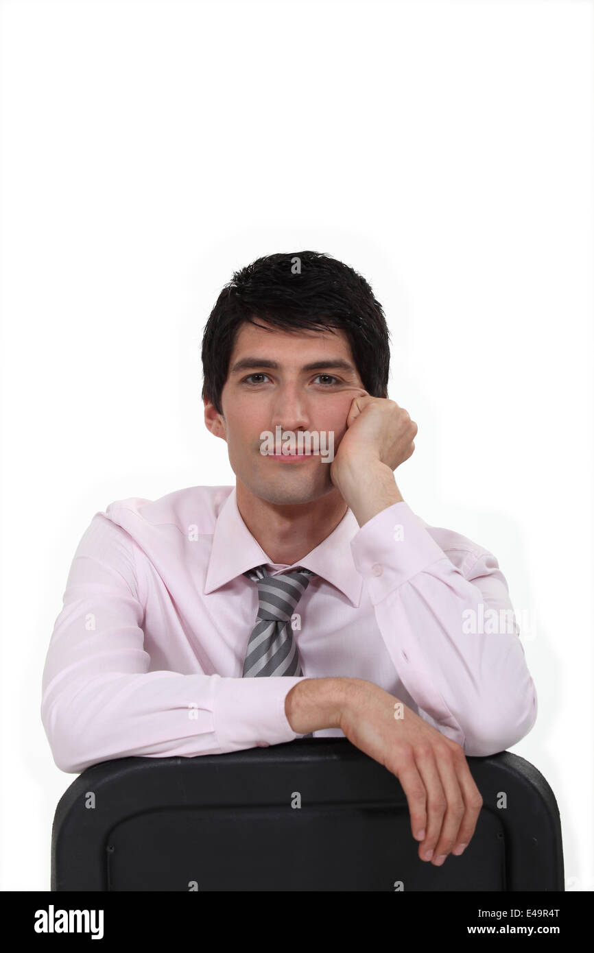 Young man leaning back in chair Stock Photo - Alamy