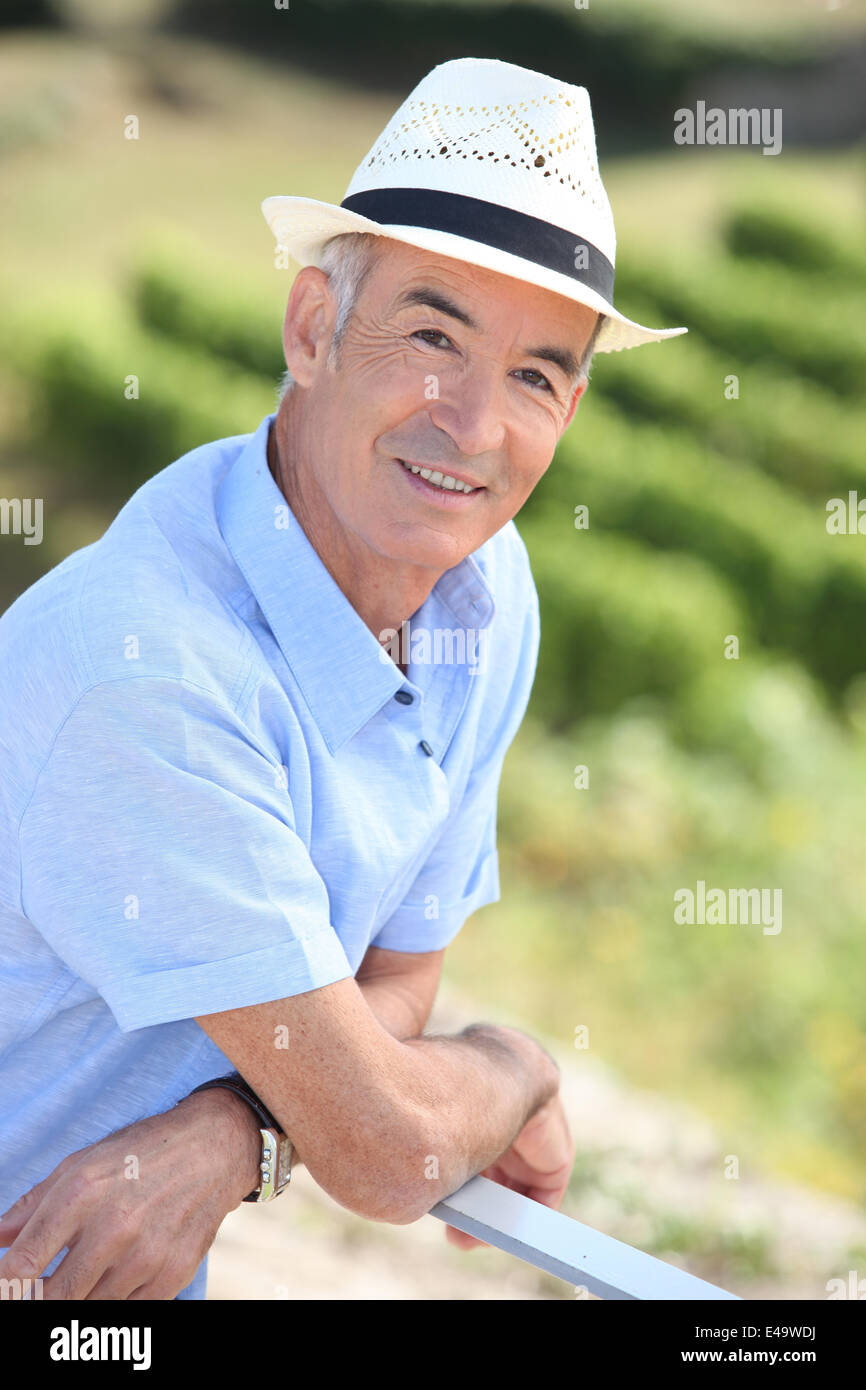 Old man leaning against railing Stock Photo - Alamy